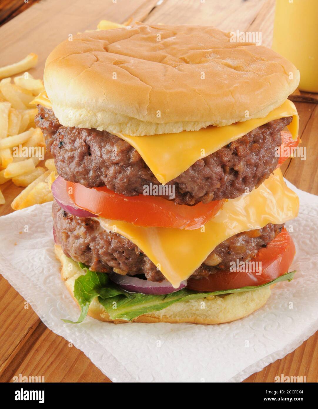 A large double decker cheeseburger with fries Stock Photo - Alamy