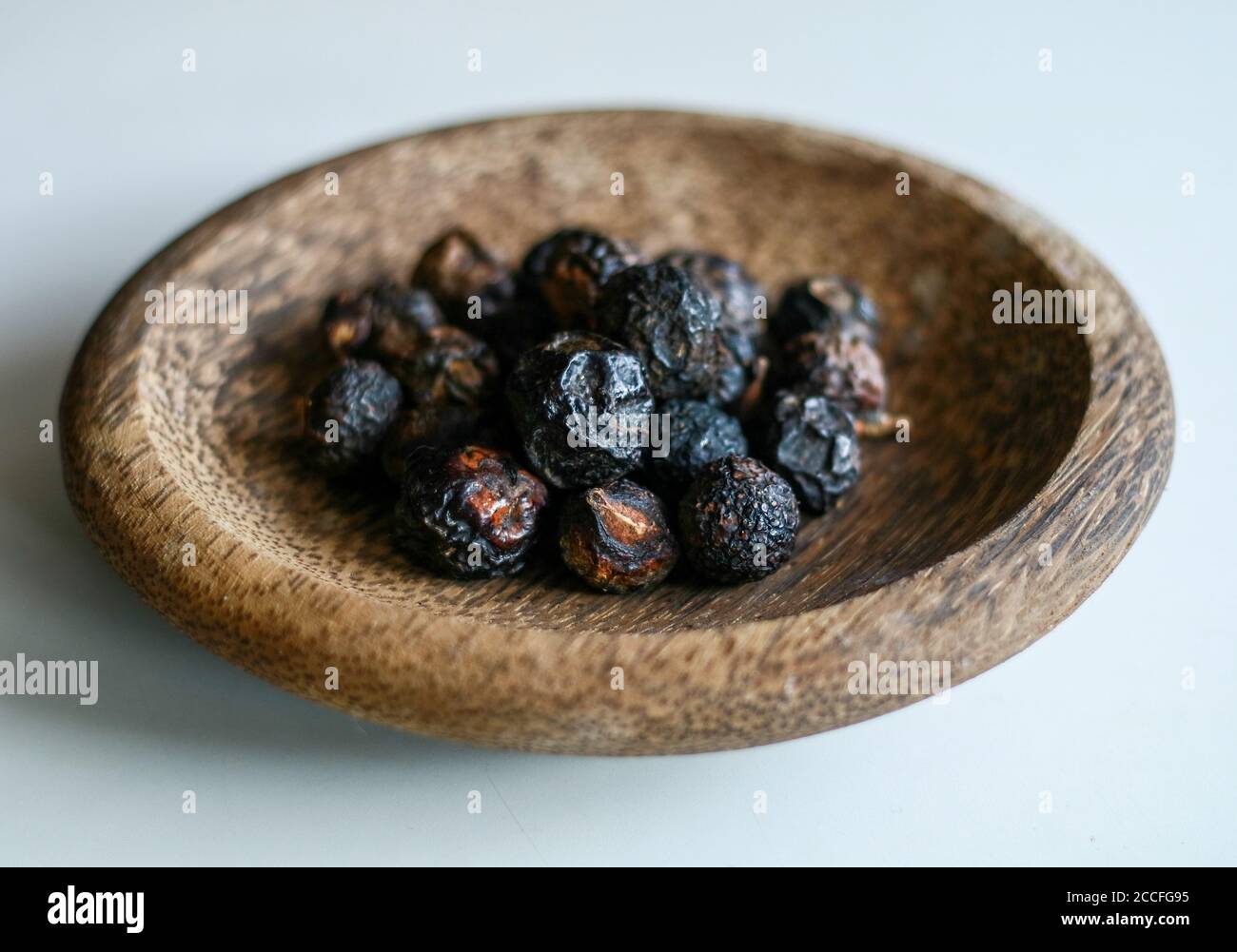 Sapindus rarak on wood plate with white background Stock Photo - Alamy