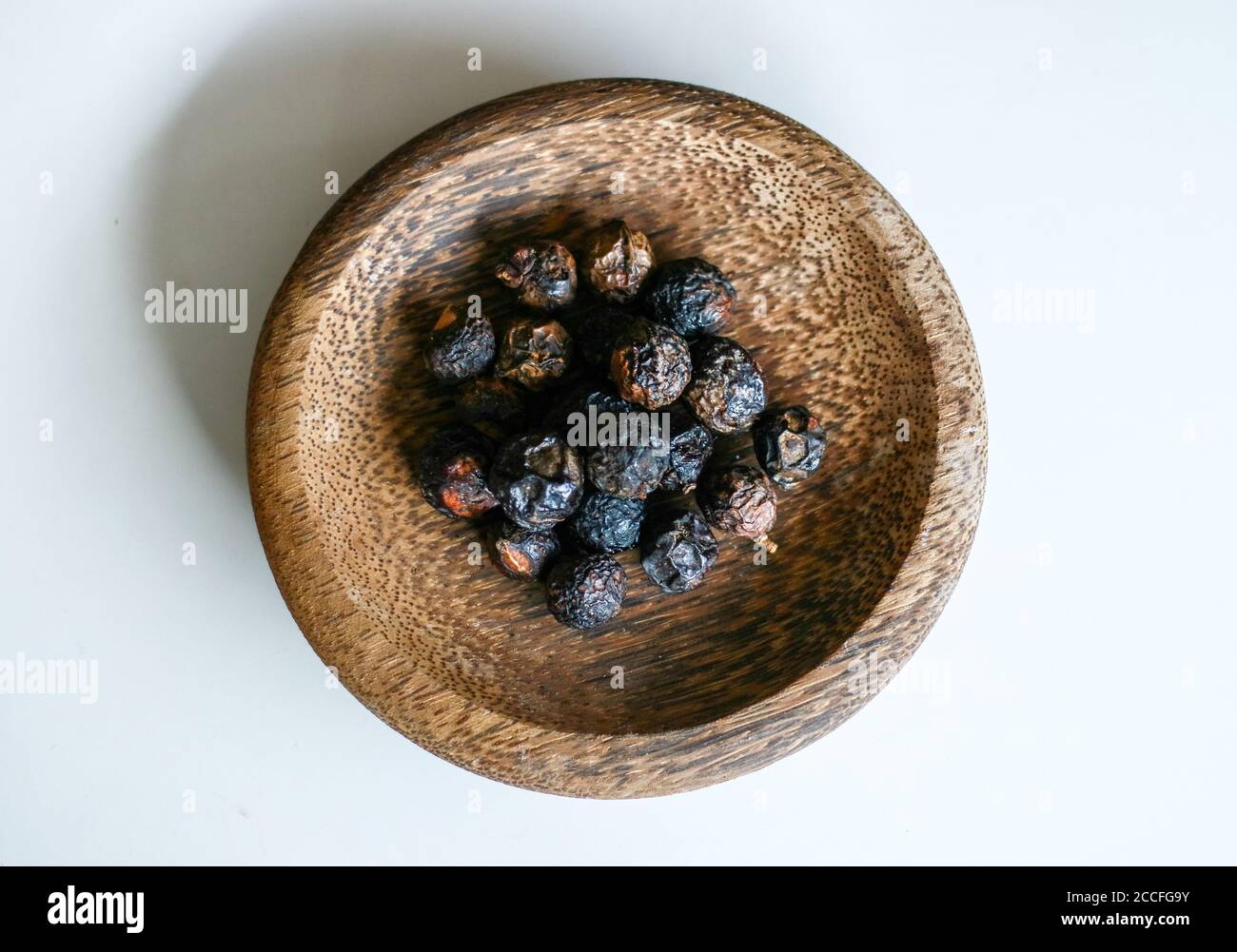 Sapindus rarak on wood plate with white background Stock Photo - Alamy