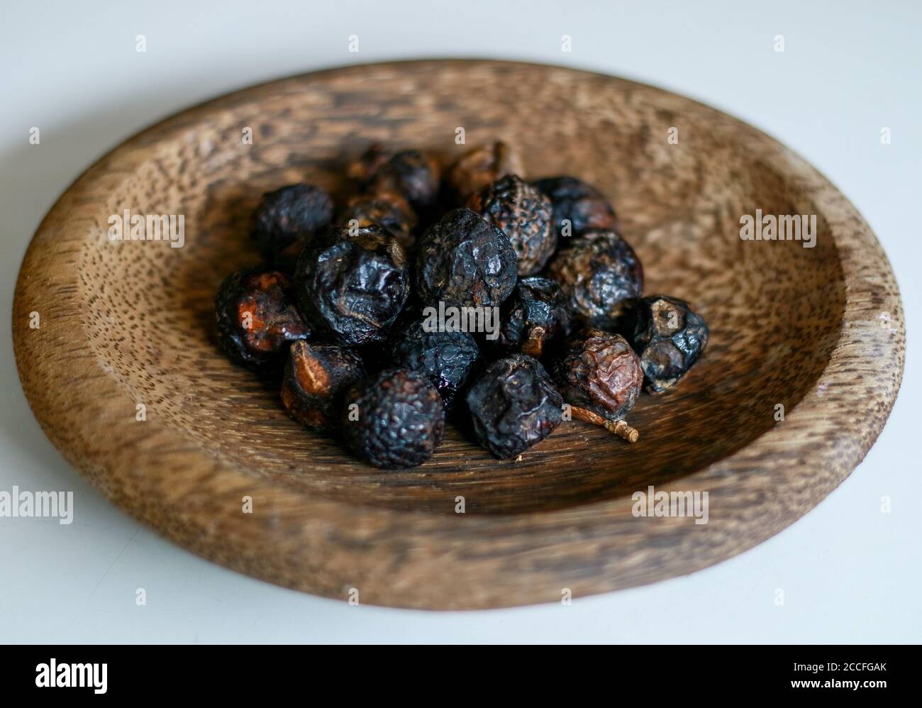 Sapindus rarak on wood plate with white background Stock Photo - Alamy
