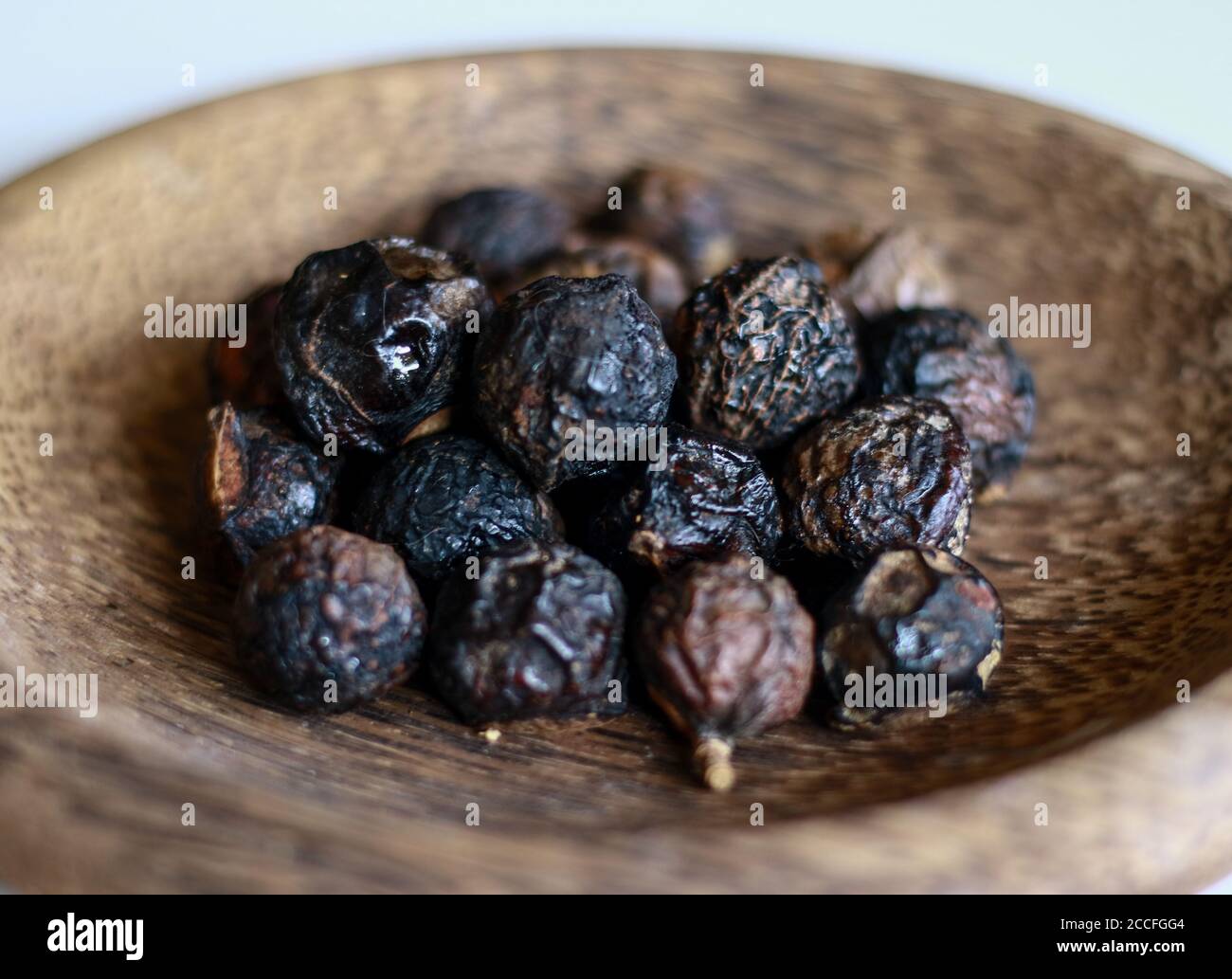 Sapindus rarak on wood plate with white background Stock Photo - Alamy