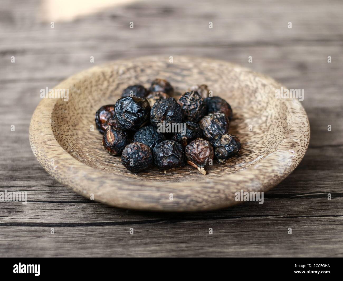 Sapindus rarak (lerak) on wood plate with wood background Stock Photo ...