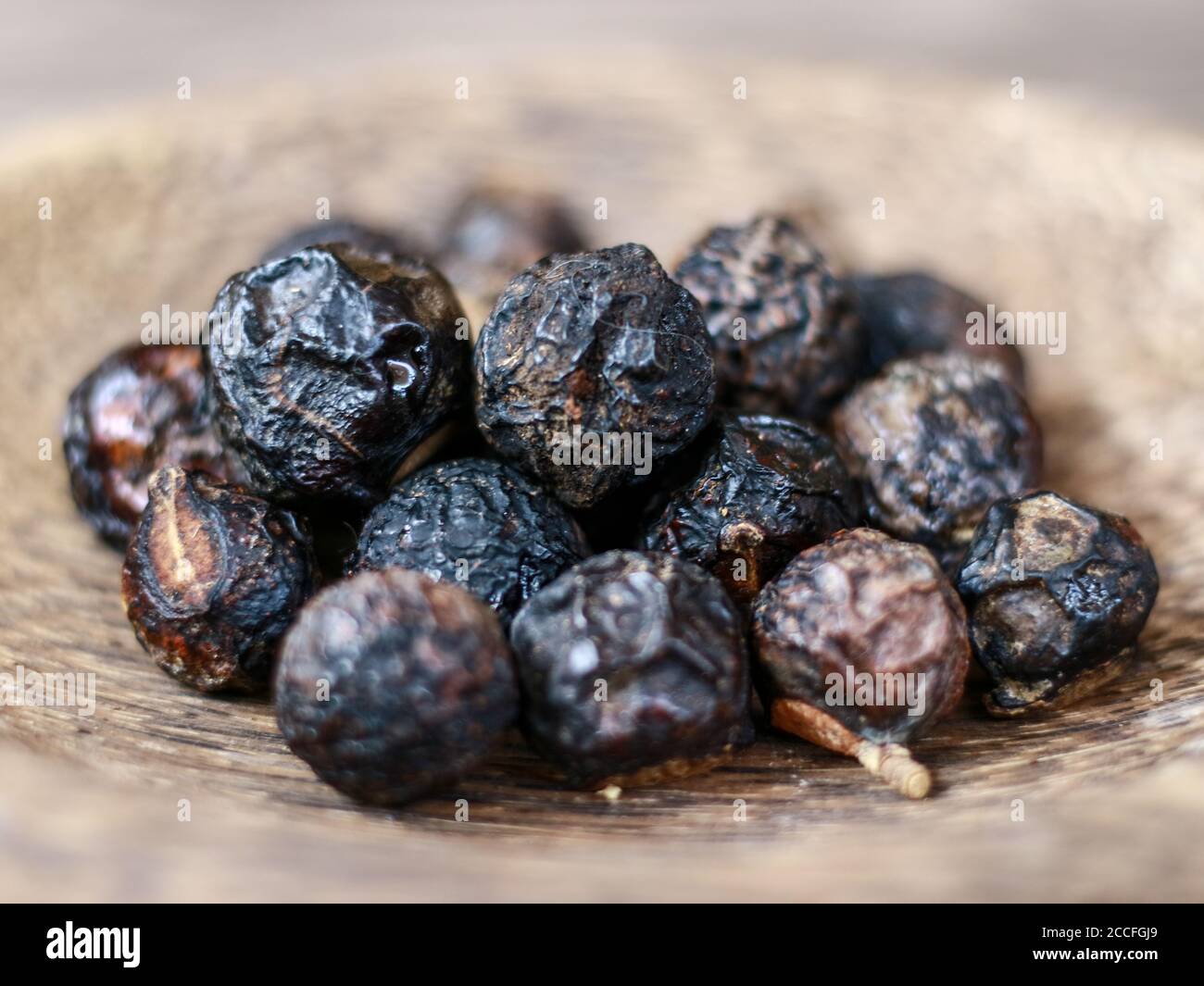 Sapindus rarak (lerak) on wood plate with wood background Stock Photo ...