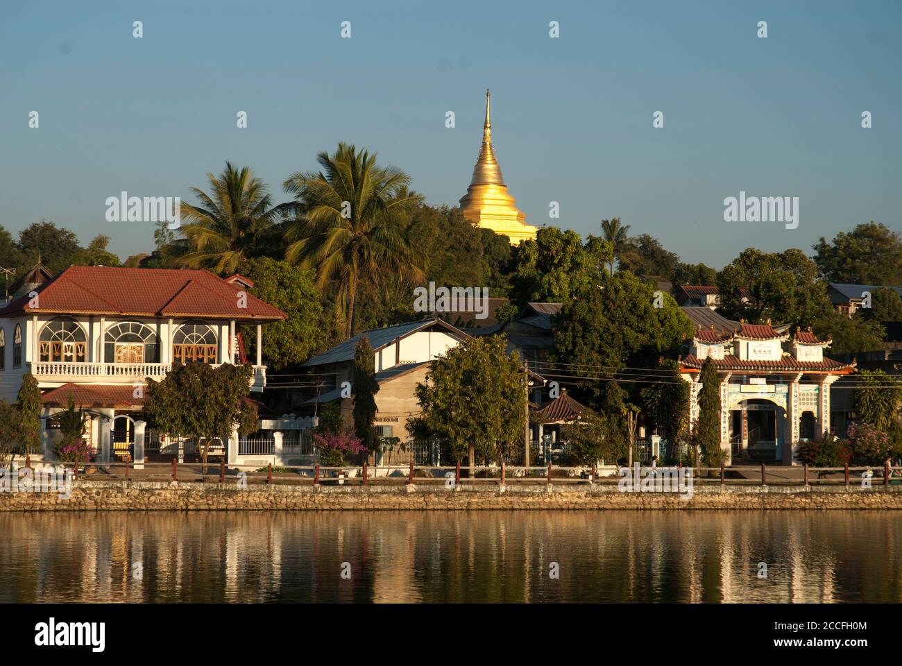 The golden spire of Wat Jom Kham overlooks the Naung Toung Lake at Kengtung, Shan State, Myanmar ...