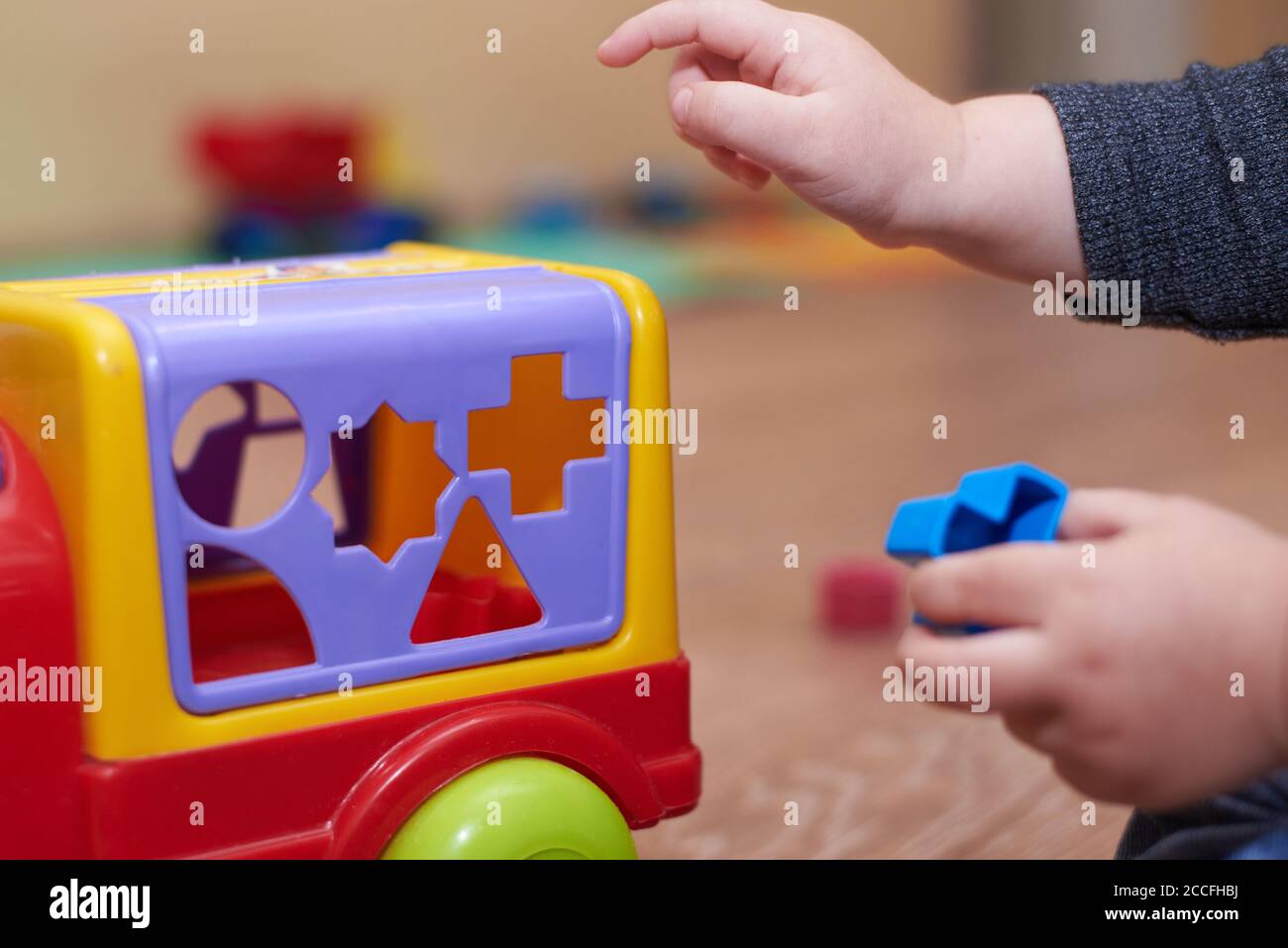 The child puts the figures in a sorter colorful car, educational toys ...