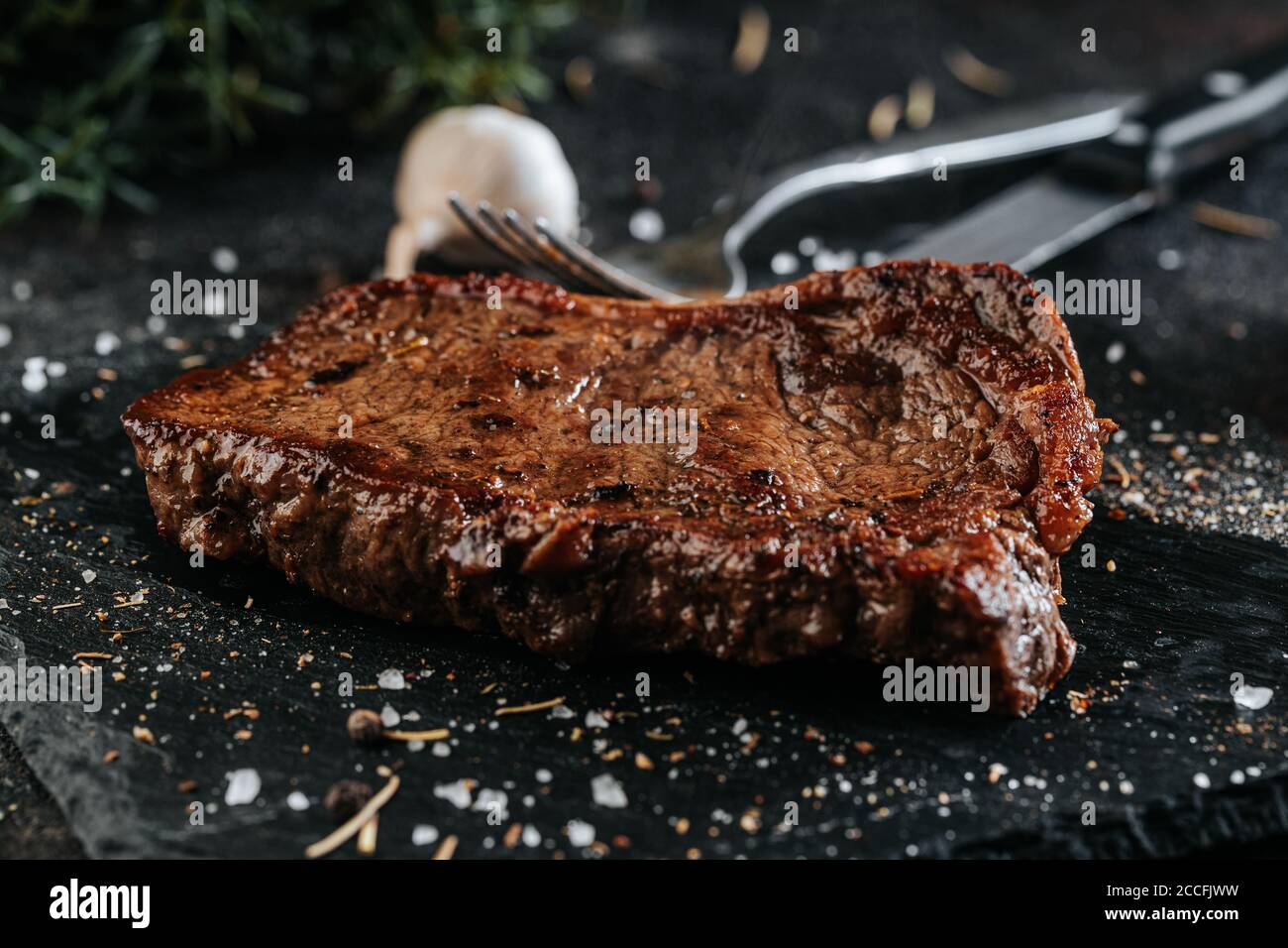 Sirloin steak preparation, seasoning with pepper and salt. Chef ...
