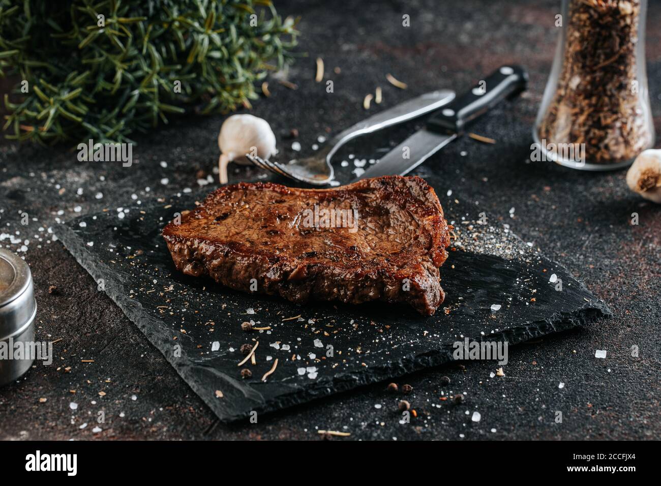 Sirloin steak preparation, seasoning with pepper and salt. Chef ...