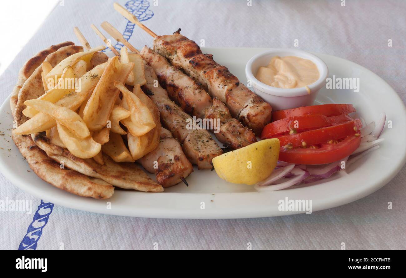 Traditional Greek food. Portion of souvlaki with fried potatoes ...