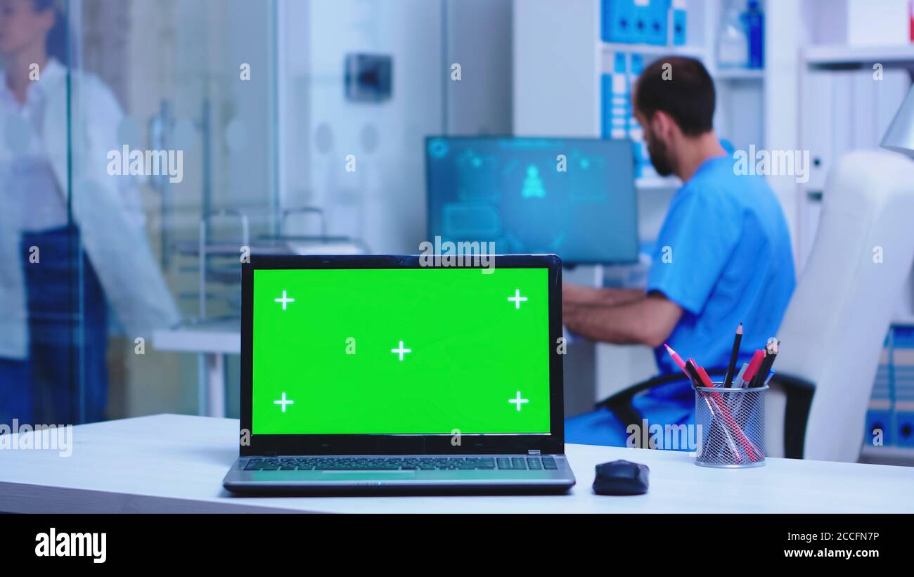 Laptop with replaceable screen in hospital cabinet, doctor wearing coat ...