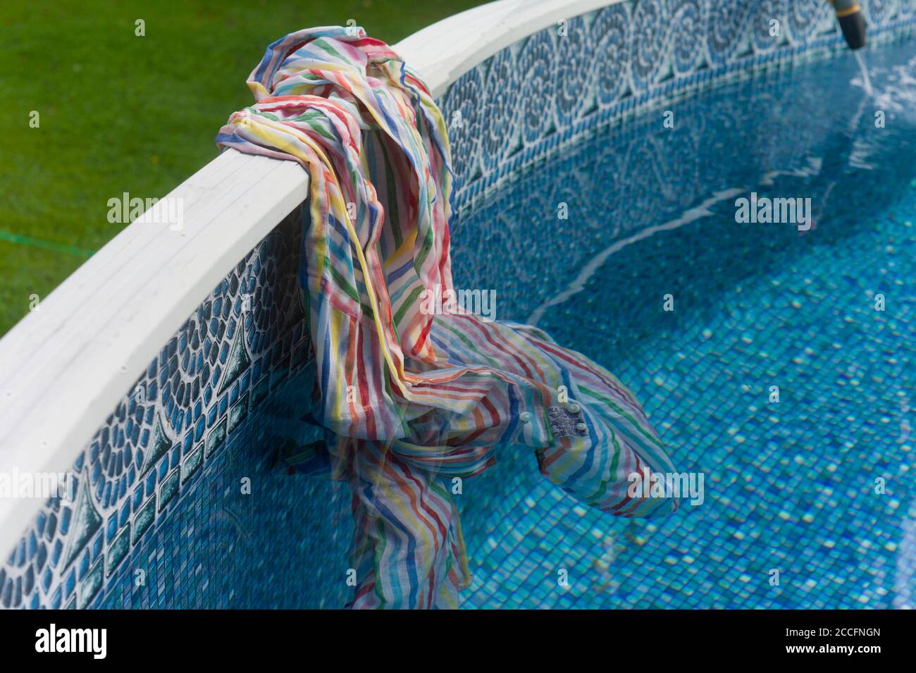 Washing colorful laundry in above ground swimming pool Stock Photo - Alamy