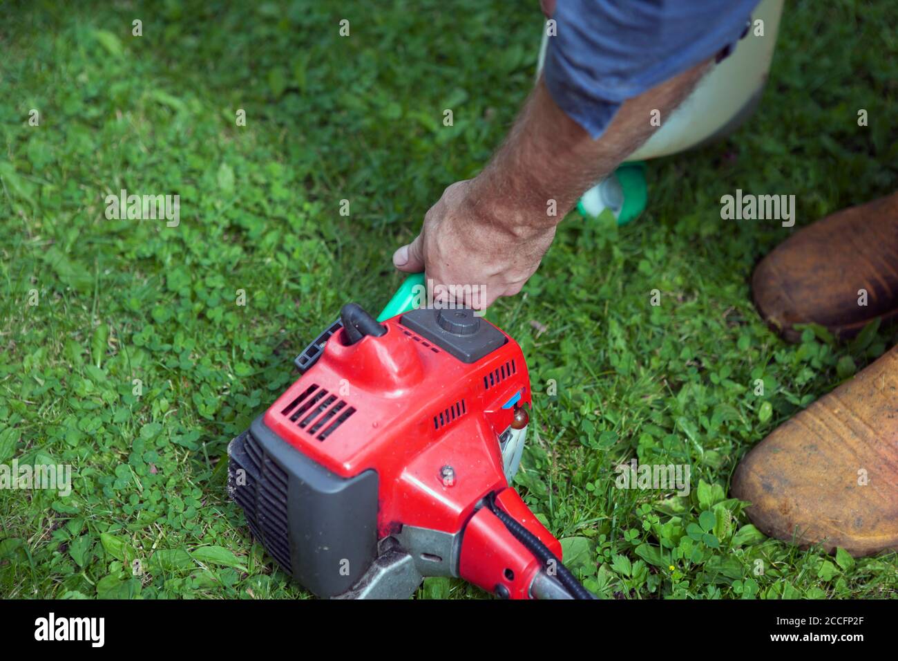 A woreker carefully pouring petrol into a chainsaw, outdoor shot Stock ...
