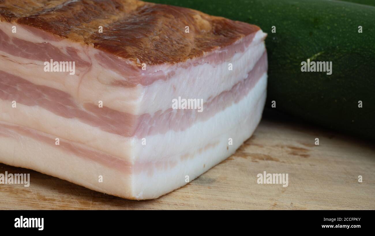 Smoked bacon meat with lots of fat on it in closeup. The meat is salt ...