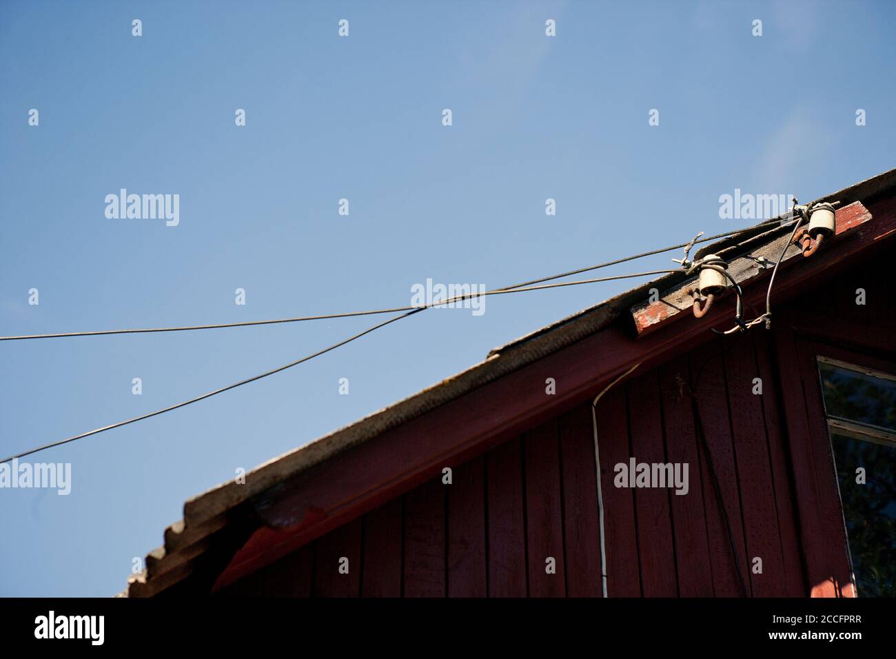 Old rooftop and angled electric cables against the sky Stock Photo - Alamy