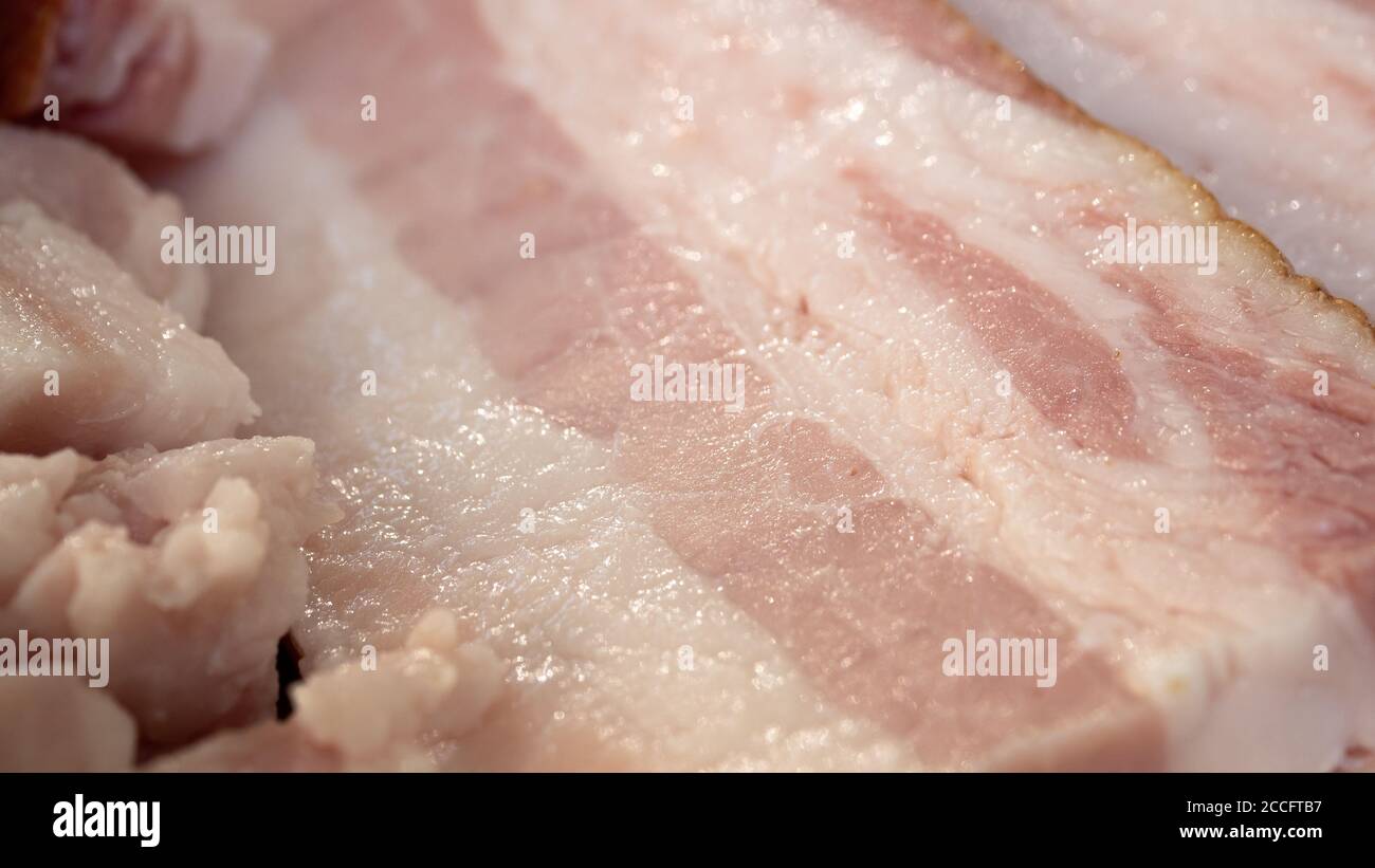 Smoked bacon meat with lots of fat on it, diced and sliced in closeup ...