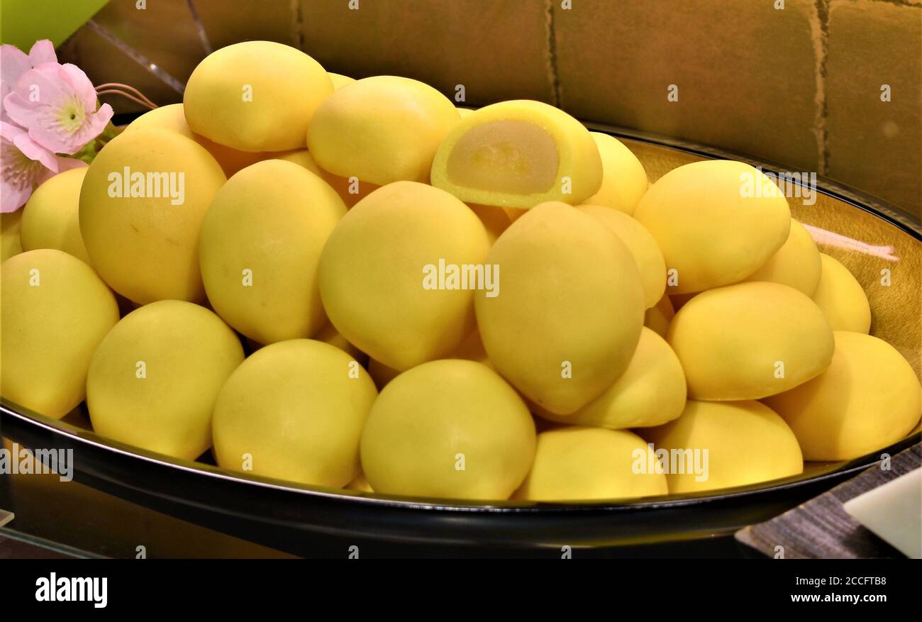 Yellow pieces of round fresh tasty bread with sweet fillings on display ...