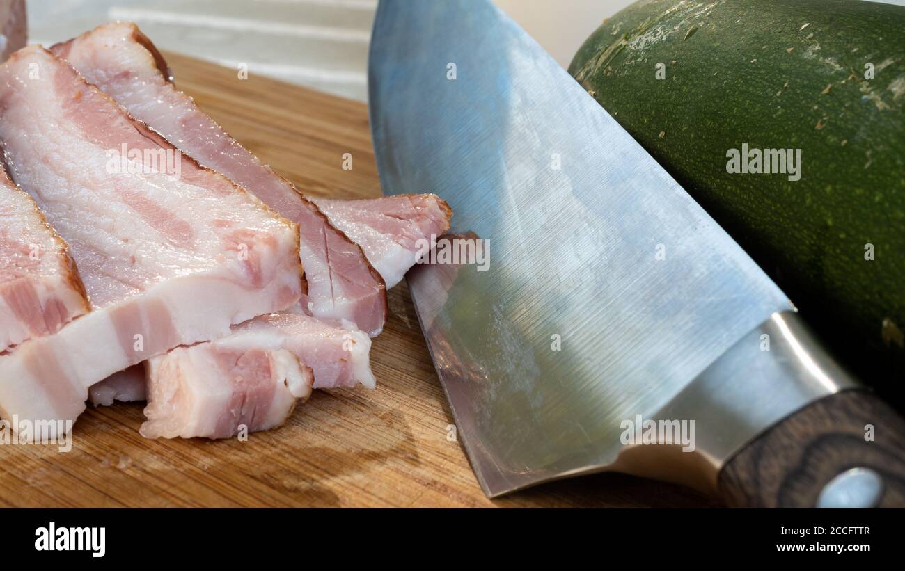 Smoked bacon meat with lots of fat on it, diced and sliced in closeup ...