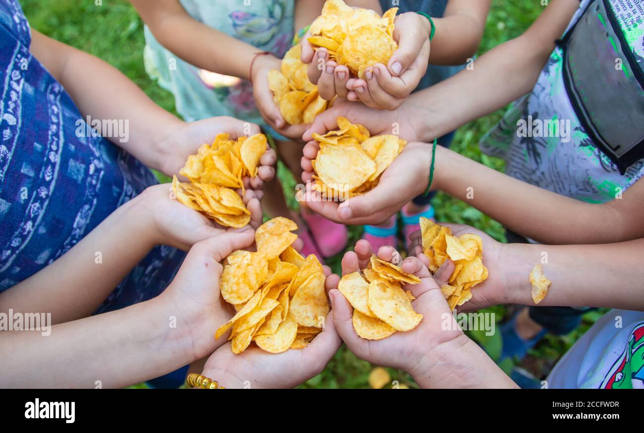Children are holding chips in their hands. Selective focus. people ...