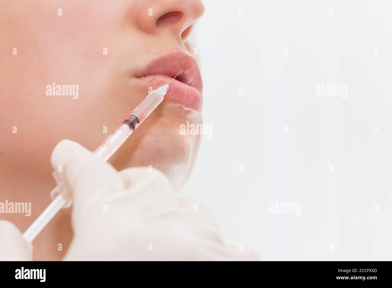 young woman gets injection in her lips. Woman in beauty salon. plastic ...