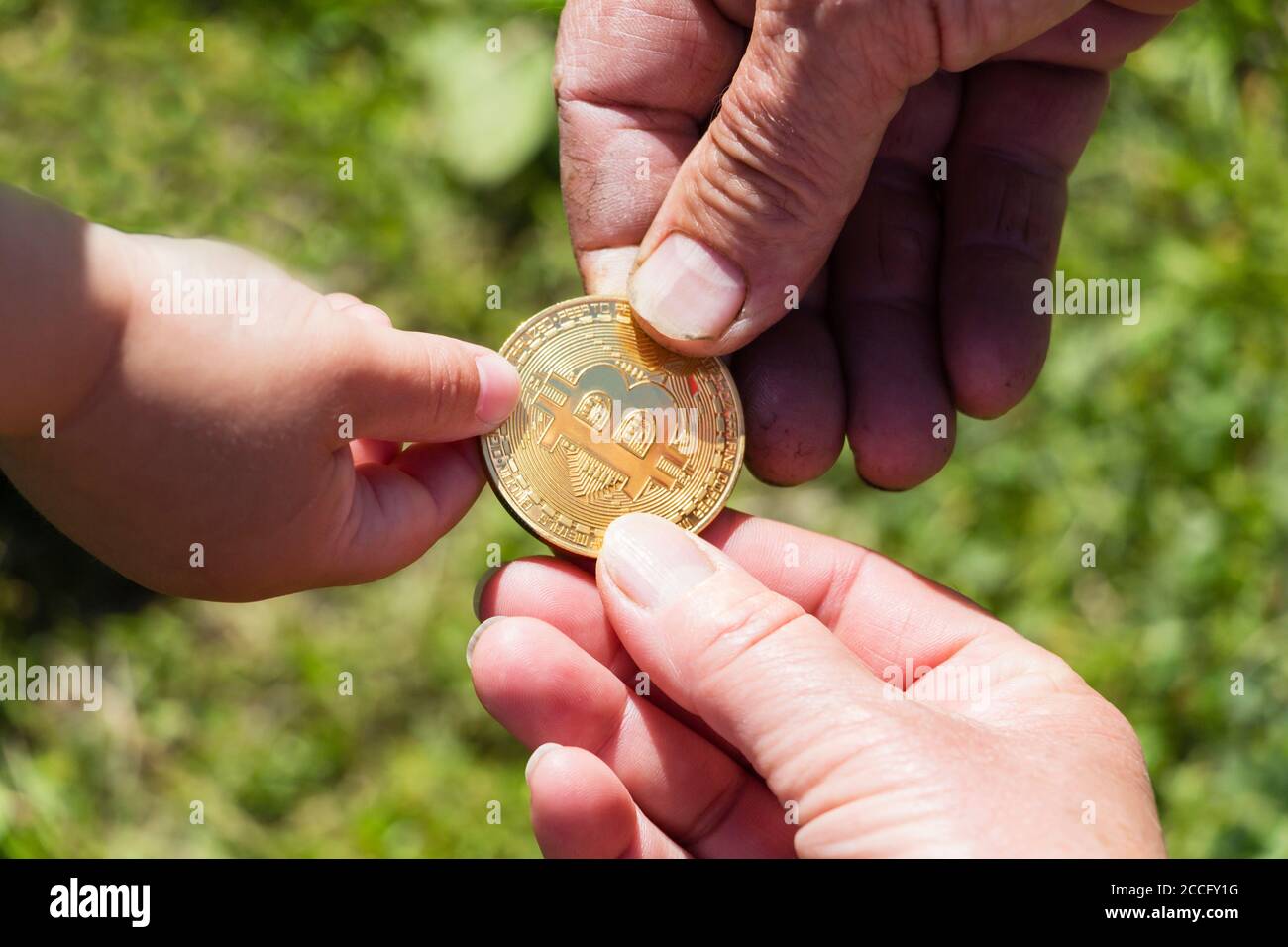 Hands of different people holding a gold coin bitcoin. Blurred ...