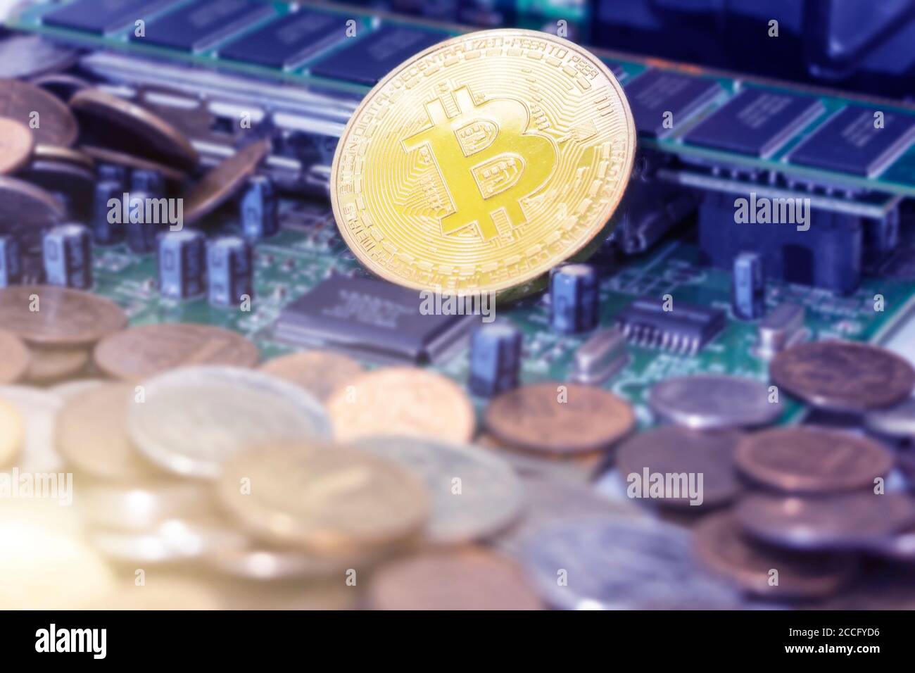 Bitcoin mining process - gold coin on computer circuit board with bitcoin processor and ...