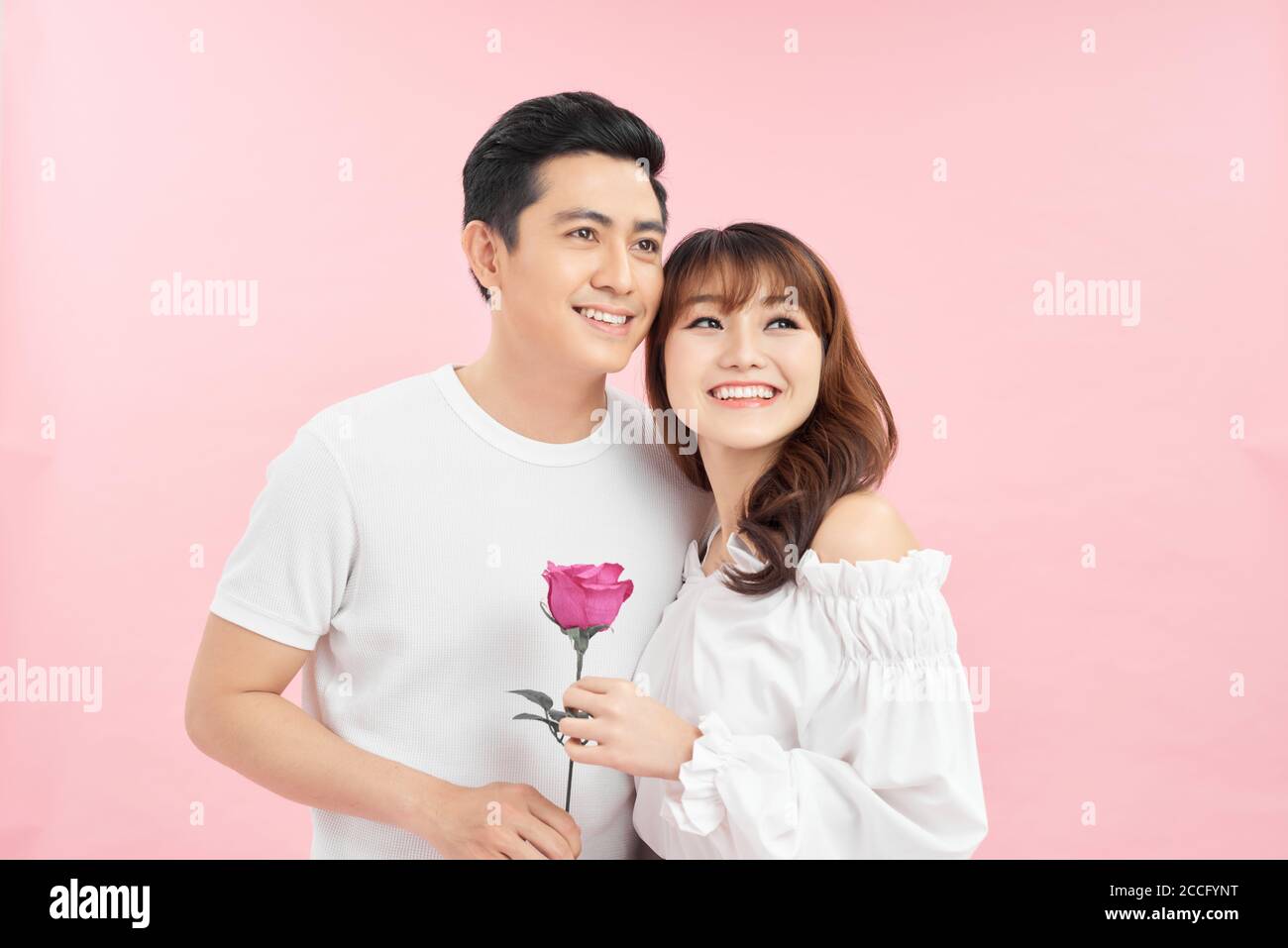 Man offering a rose to his girlfriend on pink background Stock Photo ...