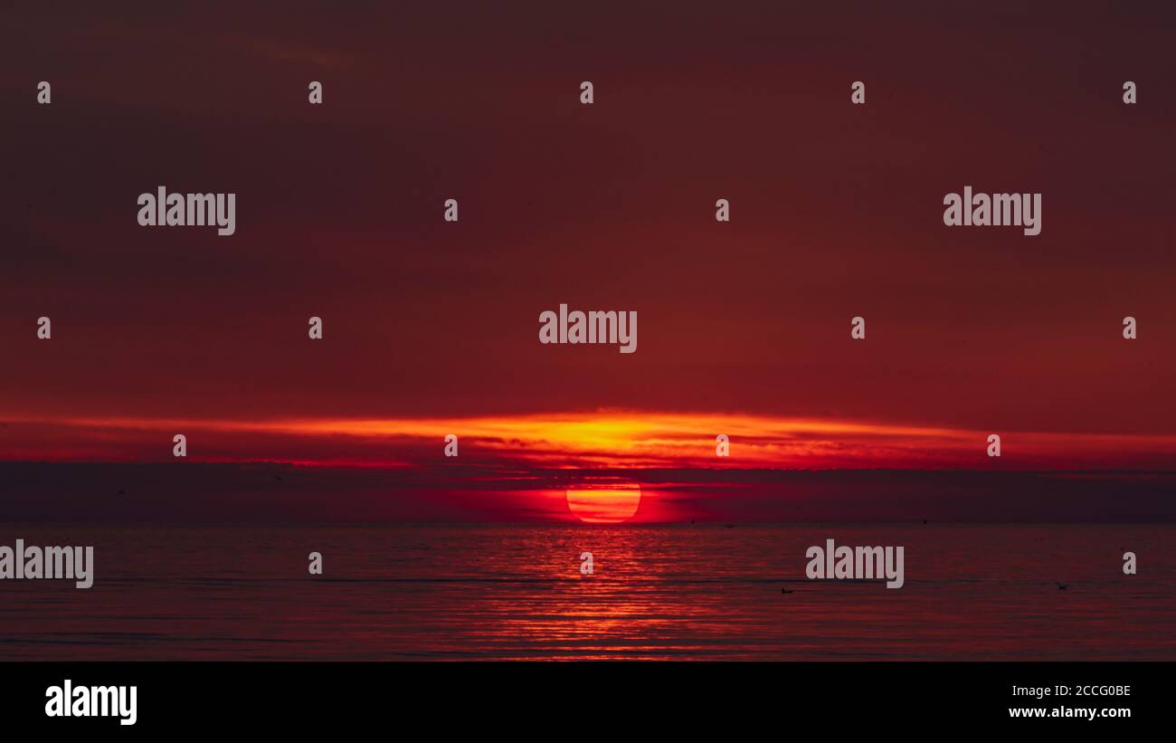 the moment of sunset when the sun touches the horizon, camouflaging ...