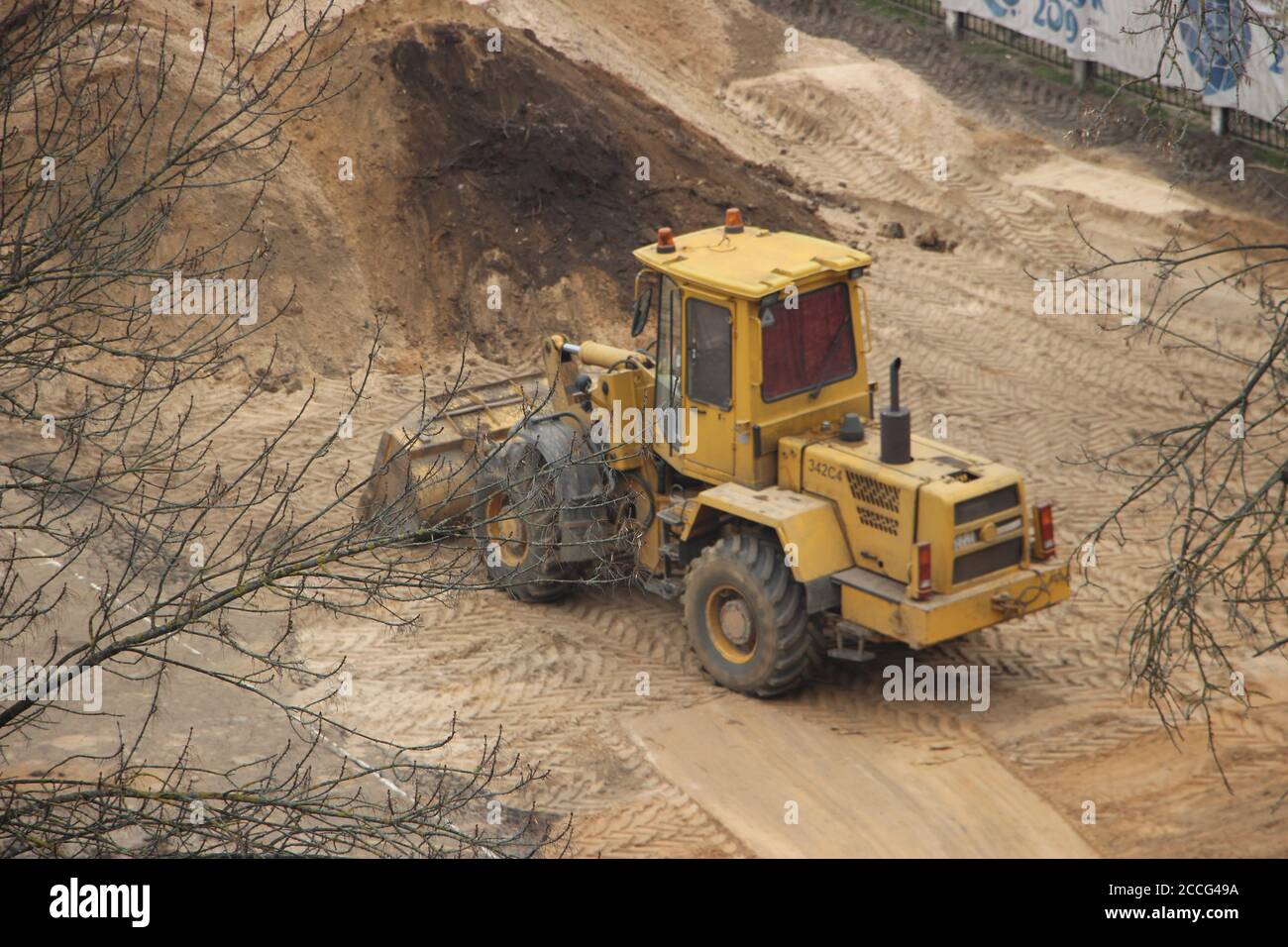 Yellow tractor collecting digging in the construction site. building ...