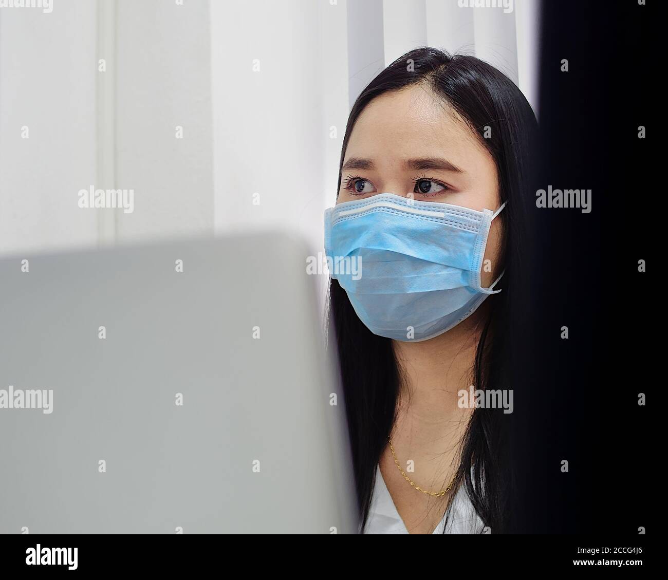 Beautiful woman wearing a face mask inside office Stock Photo - Alamy