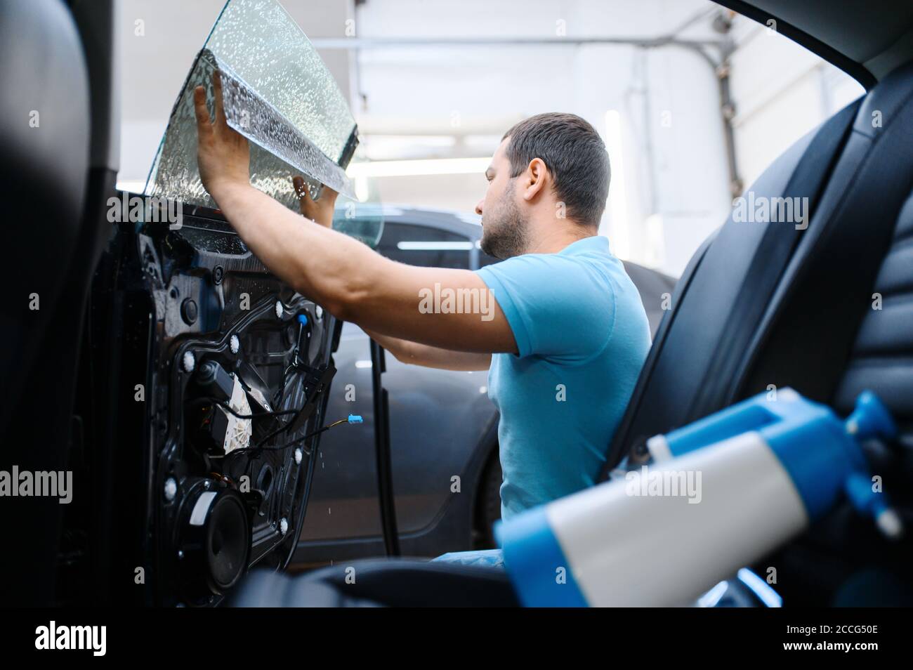 Specialist installs wetted car tinting, tuning Stock Photo - Alamy