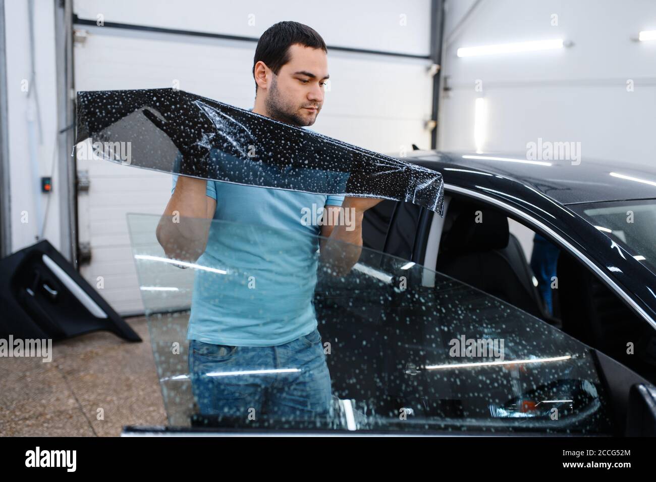 Specialist installs wetted car tinting, tuning Stock Photo - Alamy