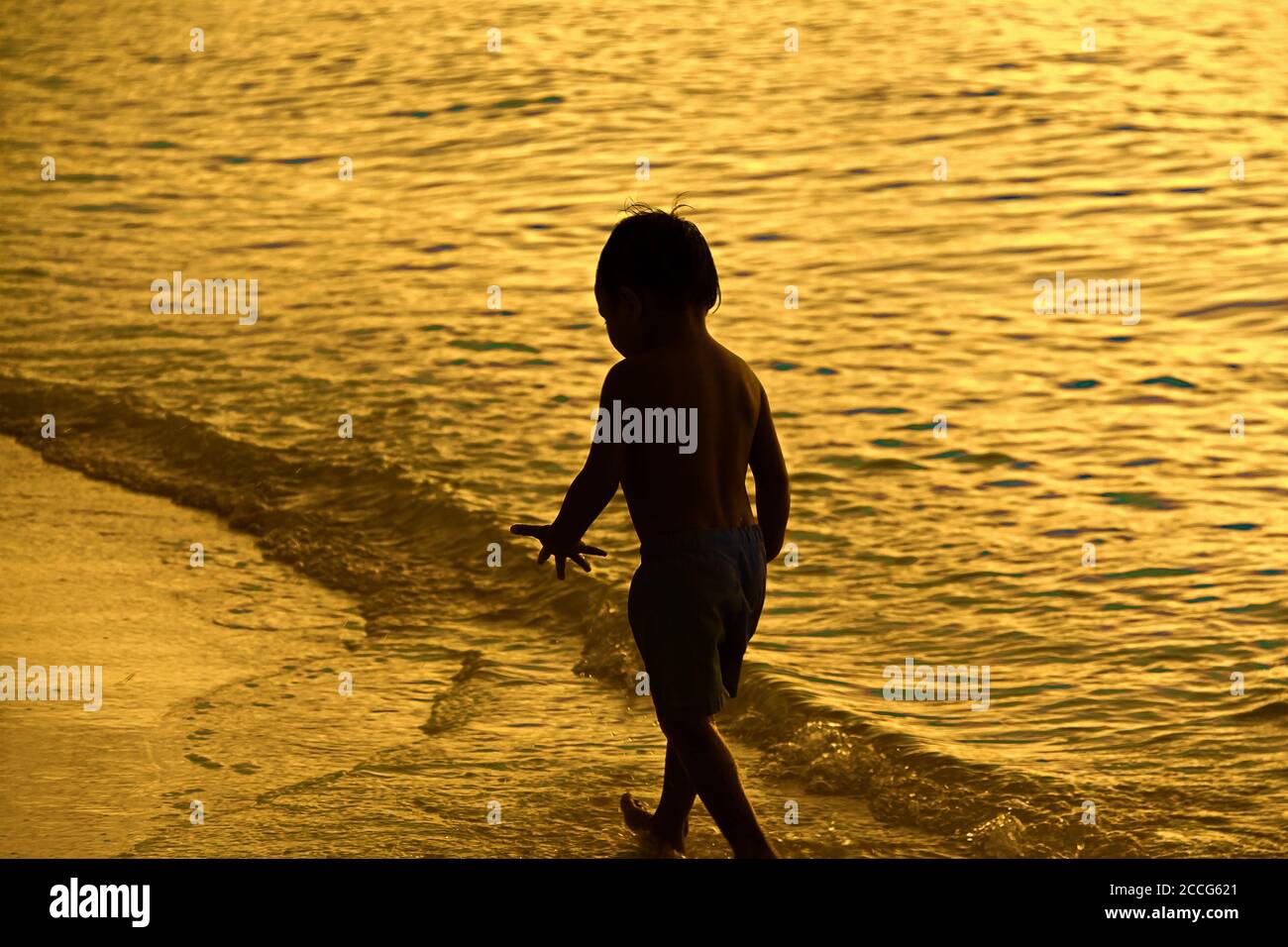kids on the beach at sunset.happy kids playing on beach at the sunset ...