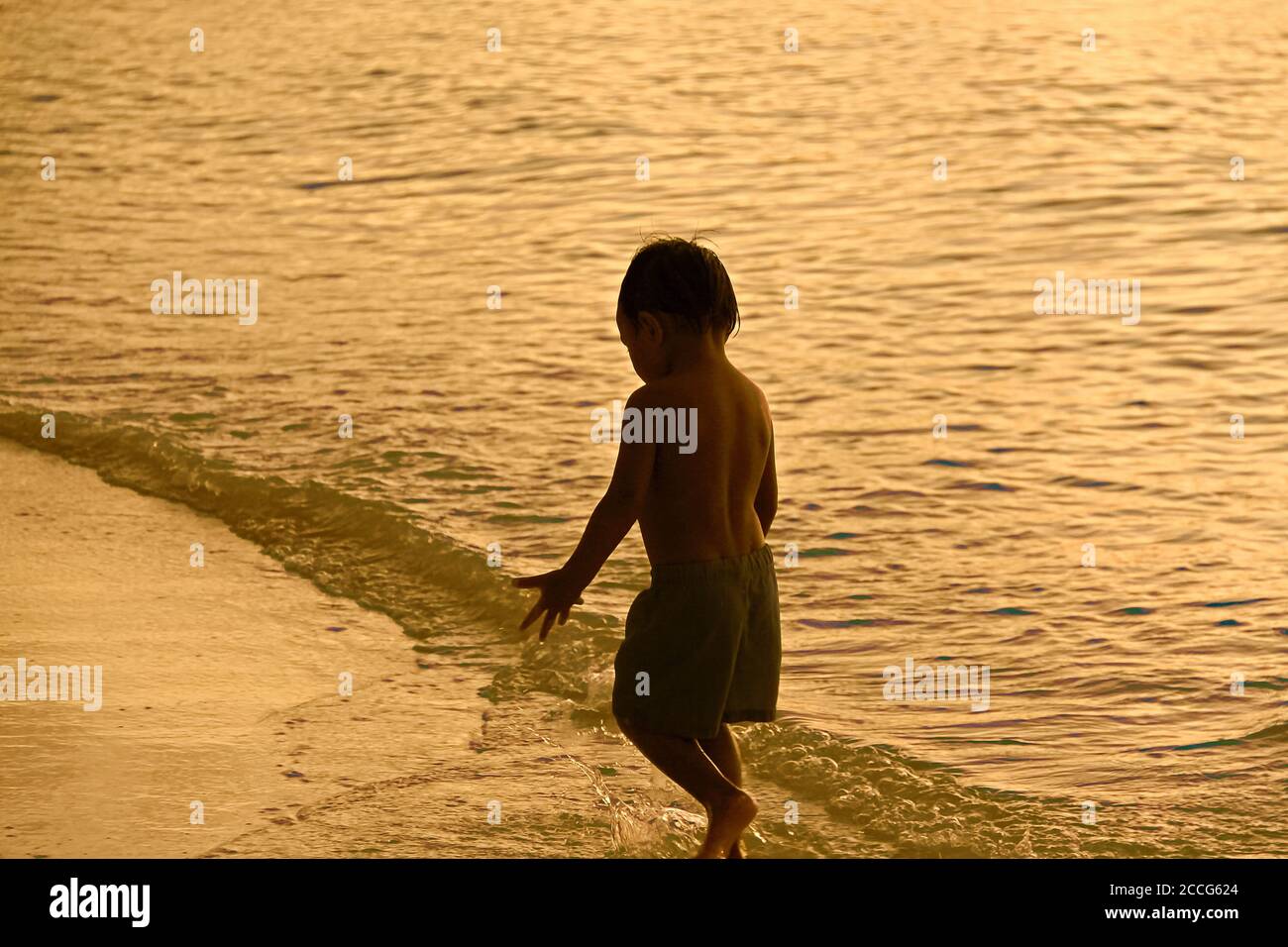 kids on the beach at sunset.happy kids playing on beach at the sunset ...