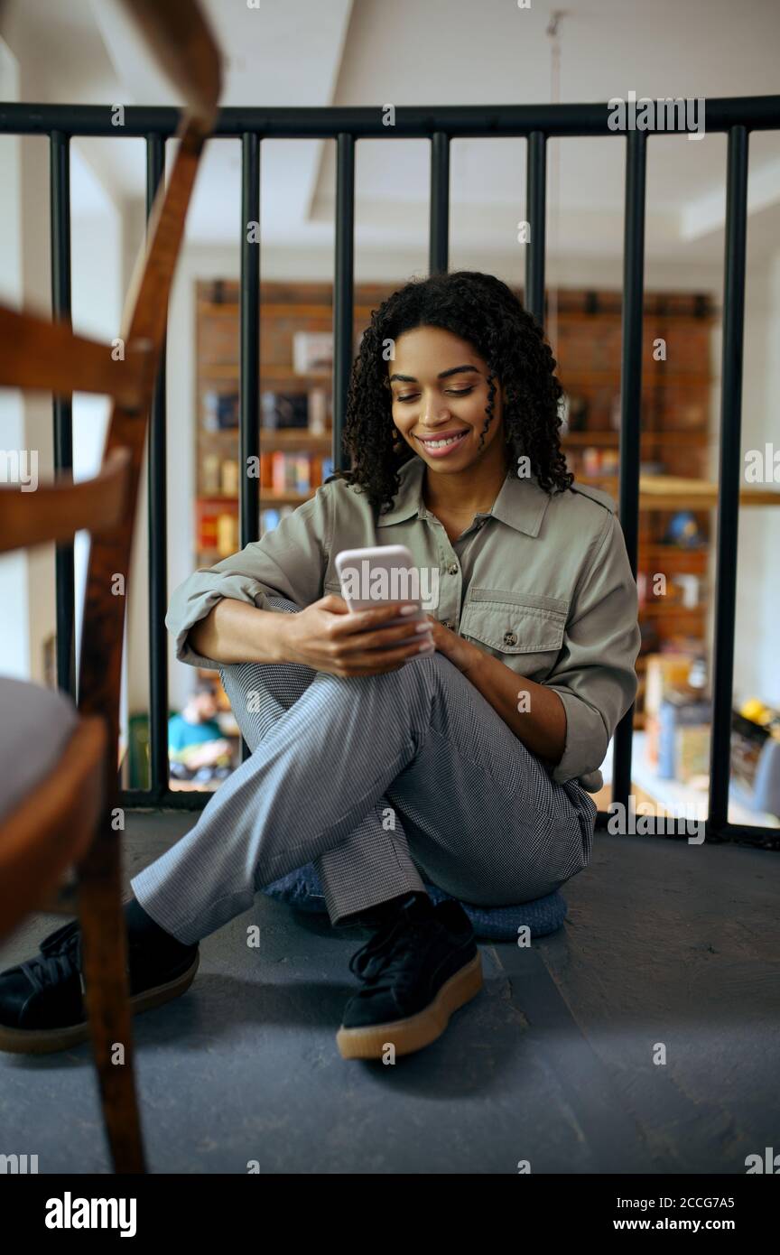 Student sitting on the floor in library cafe Stock Photo - Alamy