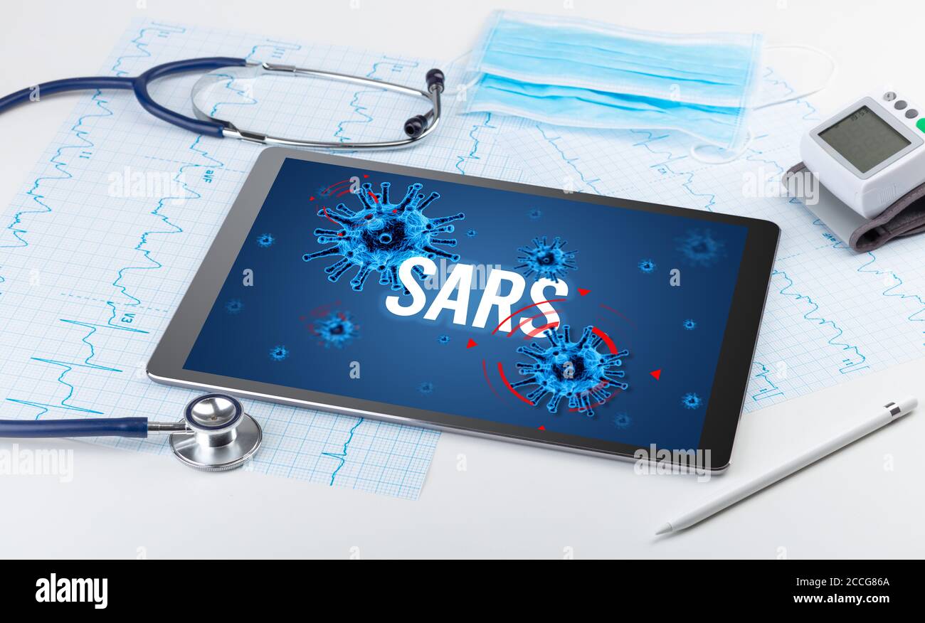 Tablet pc and doctor tools on white surface with SARS inscription ...