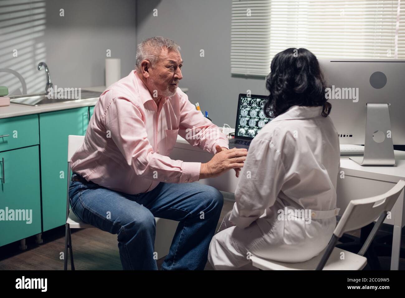 A worried patient asking the doctor questions about his diagnosis Stock ...