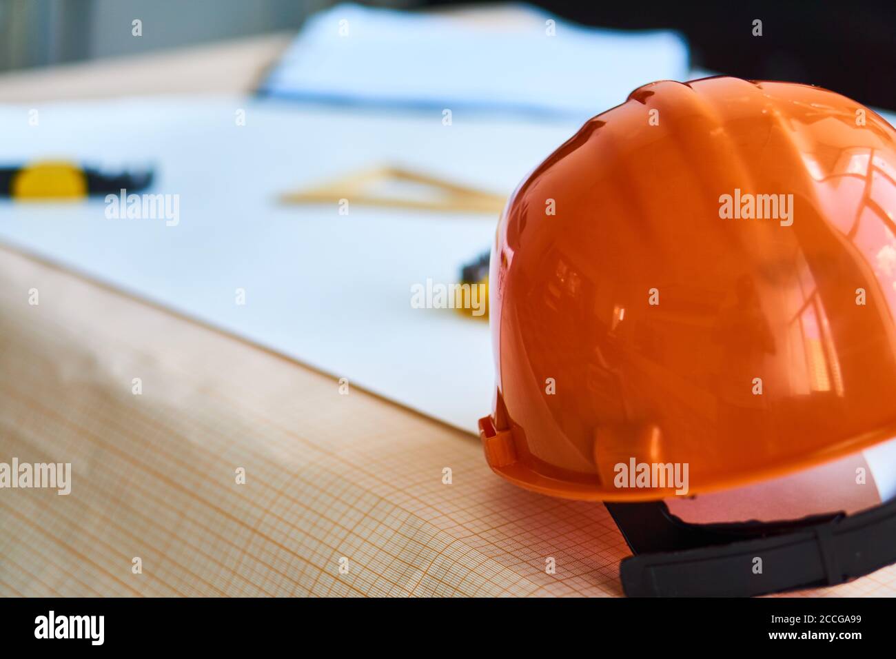 Construction tools orange hard hat engineering drawings work table ...