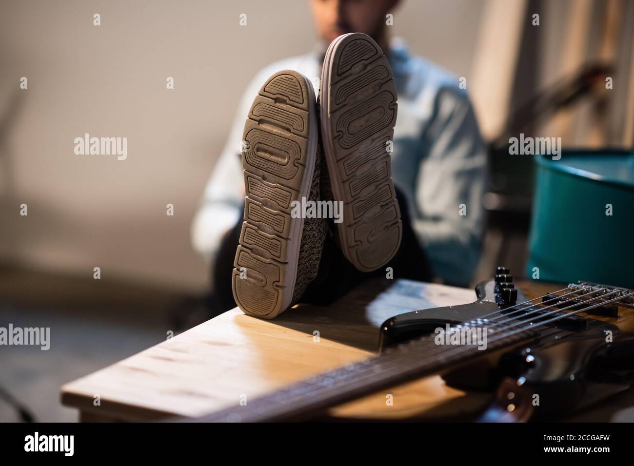 the guy is sitting with his feet in sneakers on the table, on the table ...