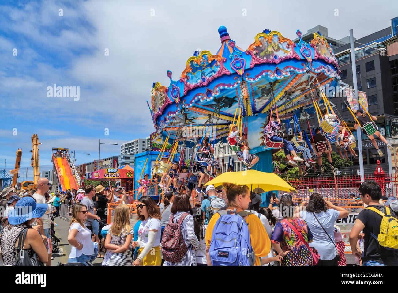 Carnival rides. Children on a swing carousel, surrounded by a large ...