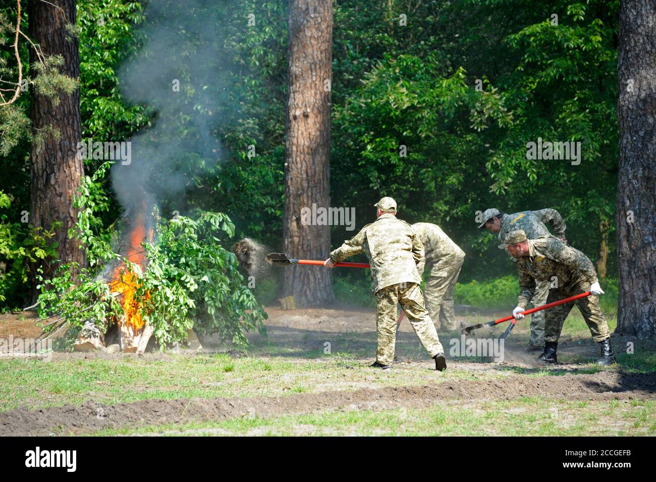 Firefighting team training: firemen in protective ensembles fighting ...