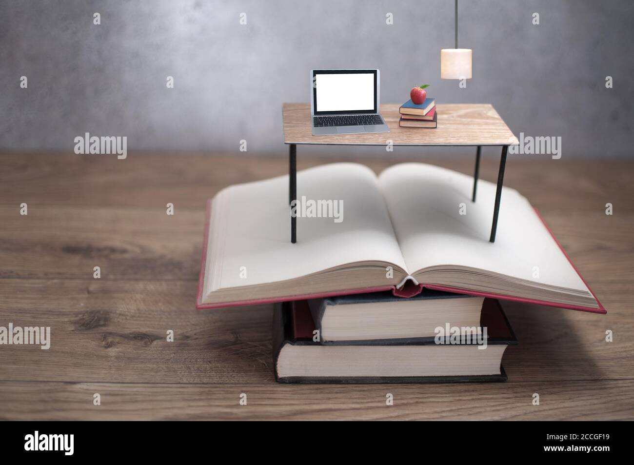 Miniature desk with laptop on top of open books Stock Photo - Alamy