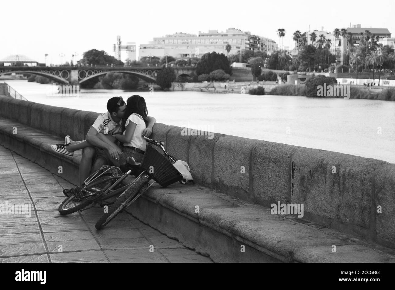 Lovers kissing by the river in Seville Stock Photo - Alamy