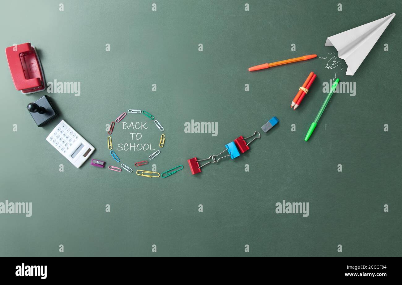 Back to school trail of stationery with a loop on a green chalkboard ...