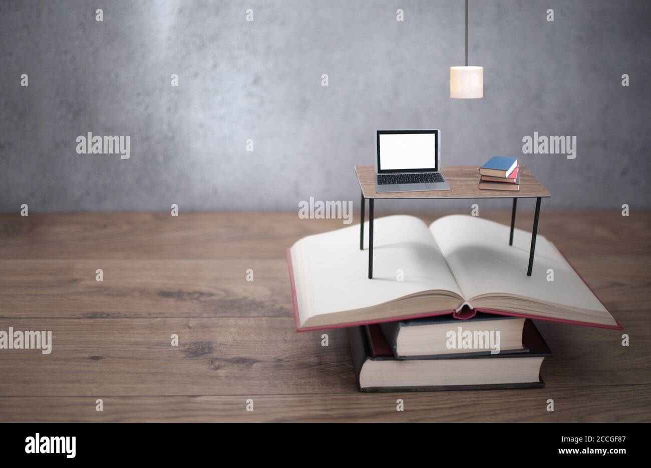 Miniature desk with laptop on top of open books Stock Photo - Alamy