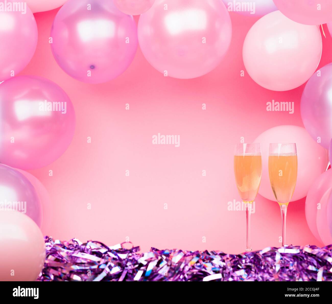 Two glasses of champagne on a pink background with pink and purple ...