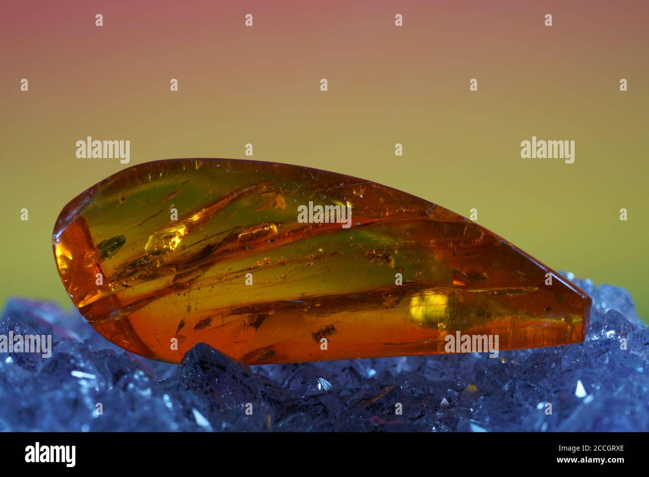 Closeup of an amber stone on crystals under the lights with a blurry ...
