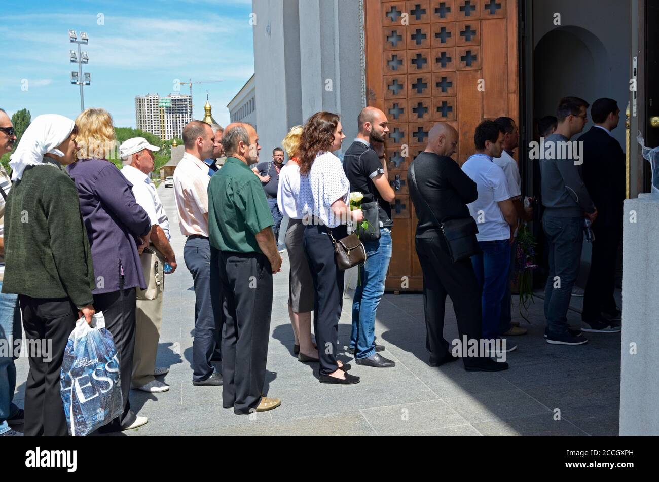 People standing in a line to enter in a church for burial service Stock ...