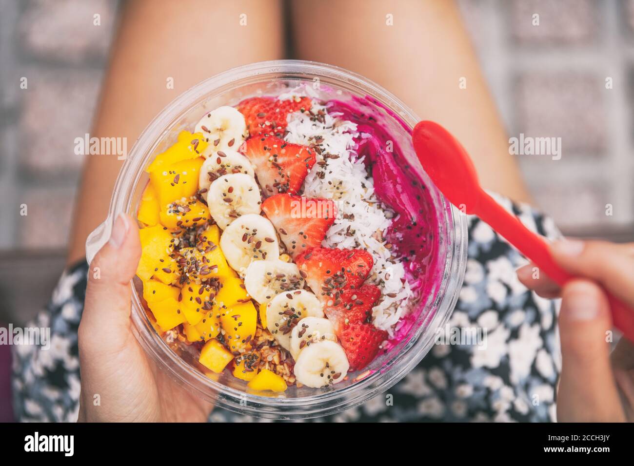 Healthy fruit breakfast pitaya bowl. Girl eating fruits smoothie ...