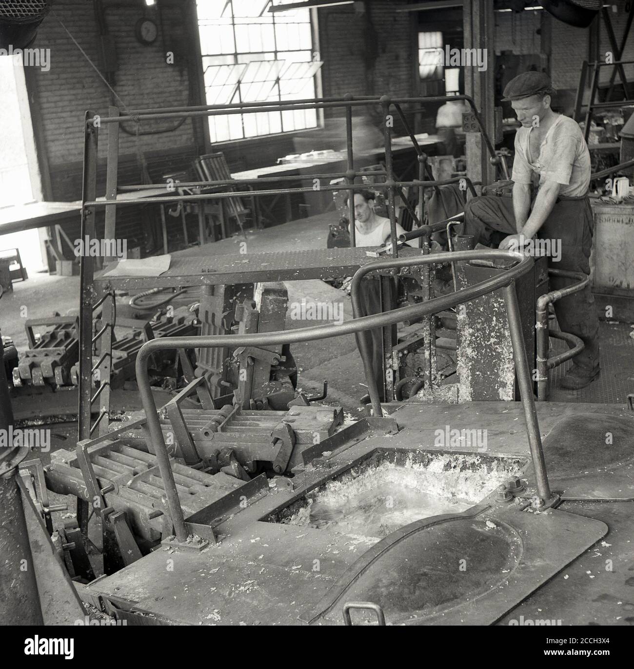 1950s, historical, industrial workers in a battery factory, one wearing ...
