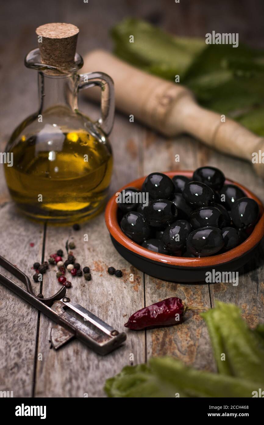 Vertical shot of products: olive oil, olives, pepper Stock Photo - Alamy