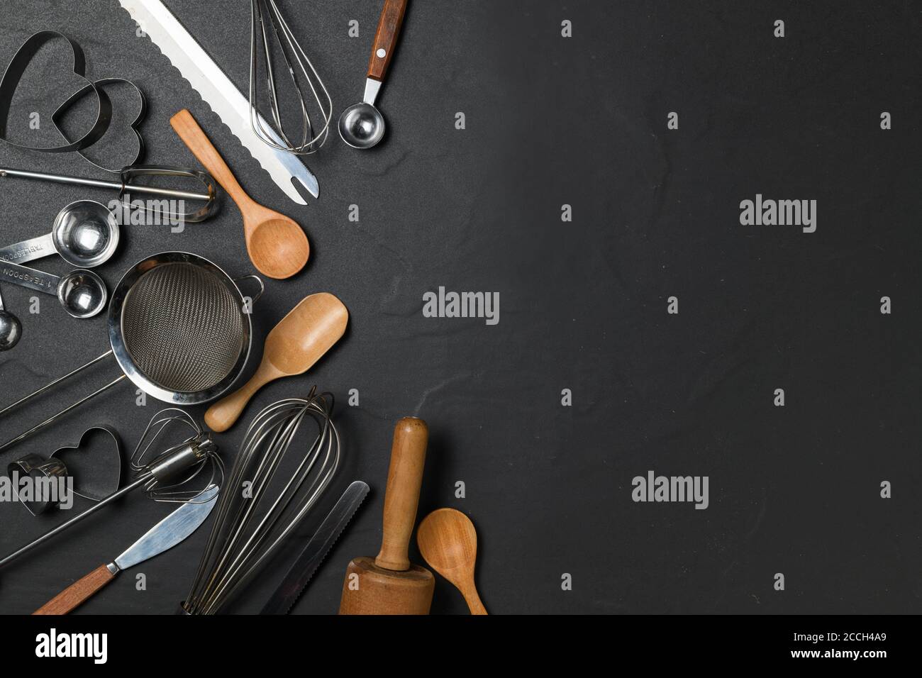 Kitchen utensils for pastries on black table and copy space, prepare ...